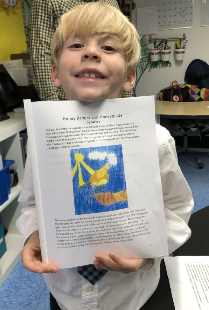 Student Holding Their Writing and Art - Changing The Subject